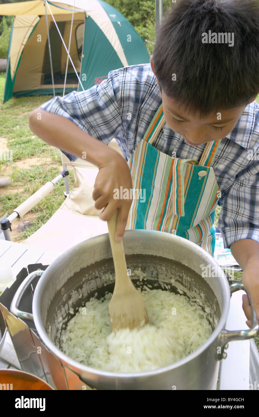 Boy Cooking at Campsite Stock Photo - Alamy