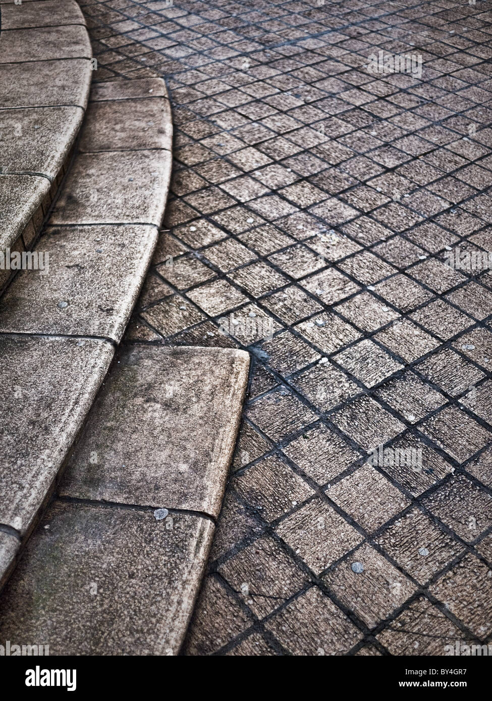 Curved stone steps on crosshatch pavement Stock Photo - Alamy
