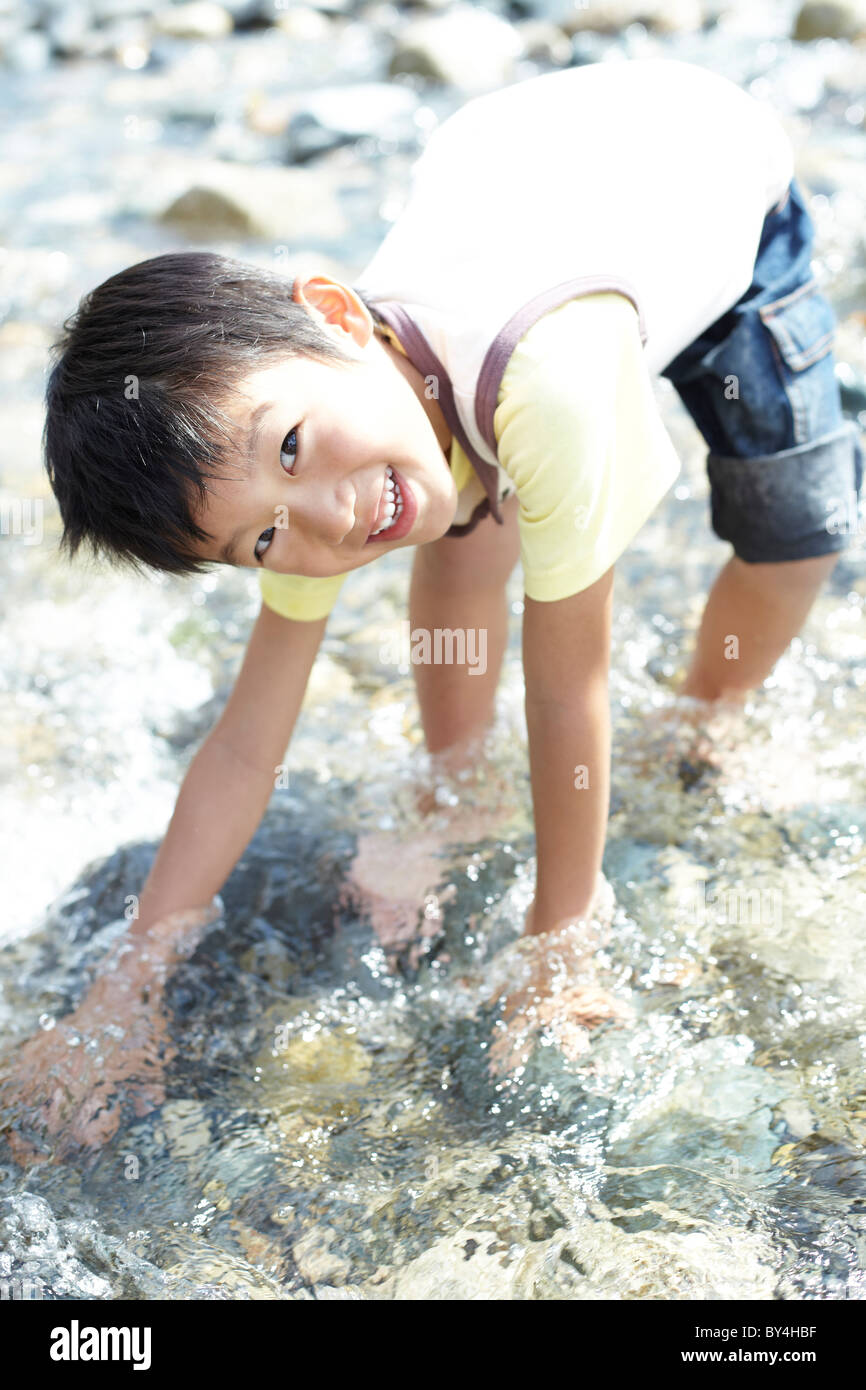 Boy Playing in River Stock Photo - Alamy