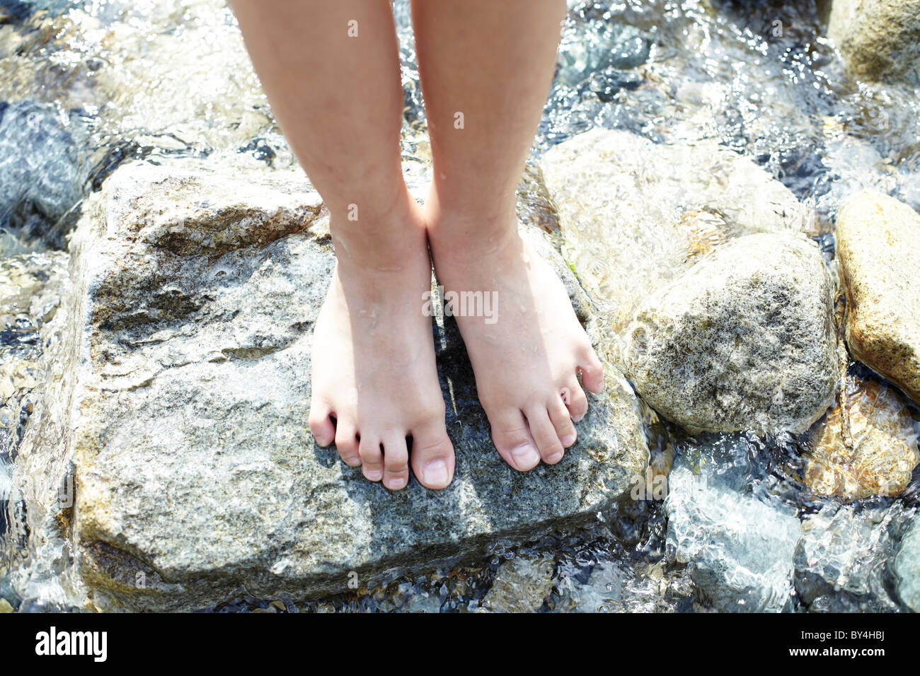 Boy Standing Barefoot on Stone Stock Photo - Alamy