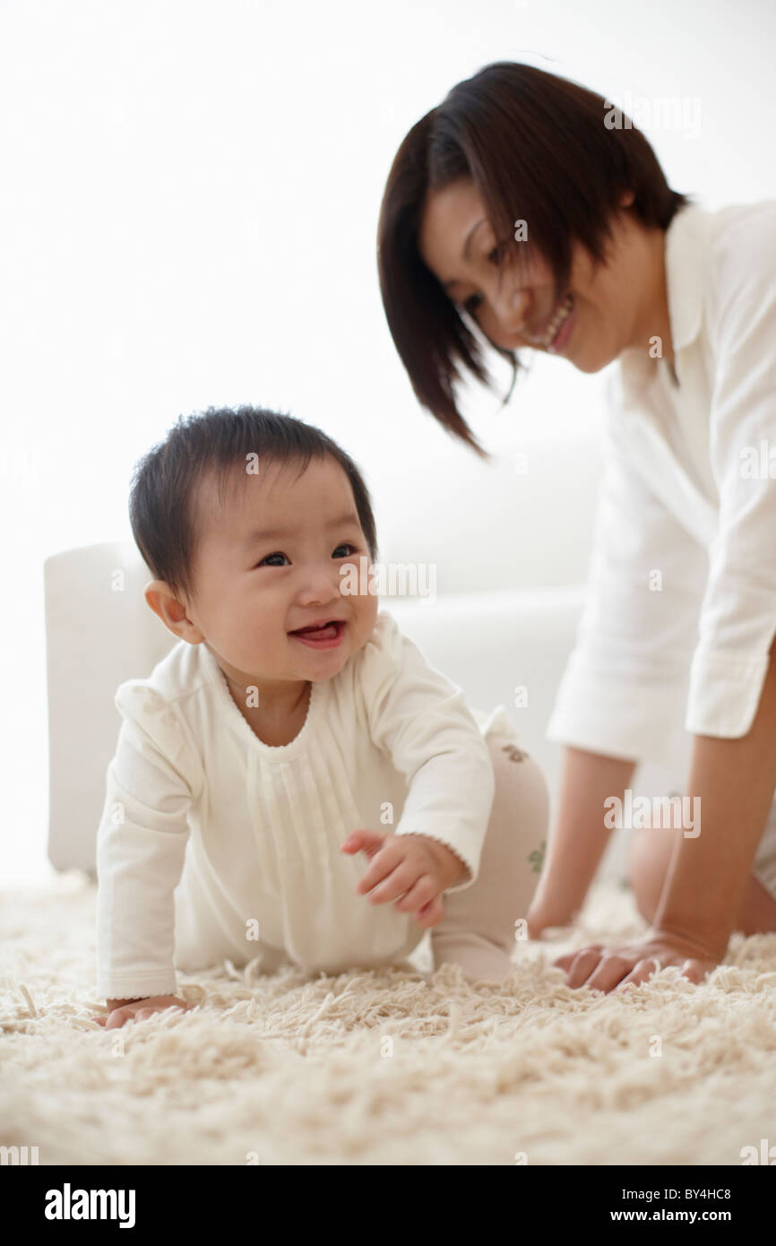 Mother Watching Baby Boy Crawling Stock Photo - Alamy