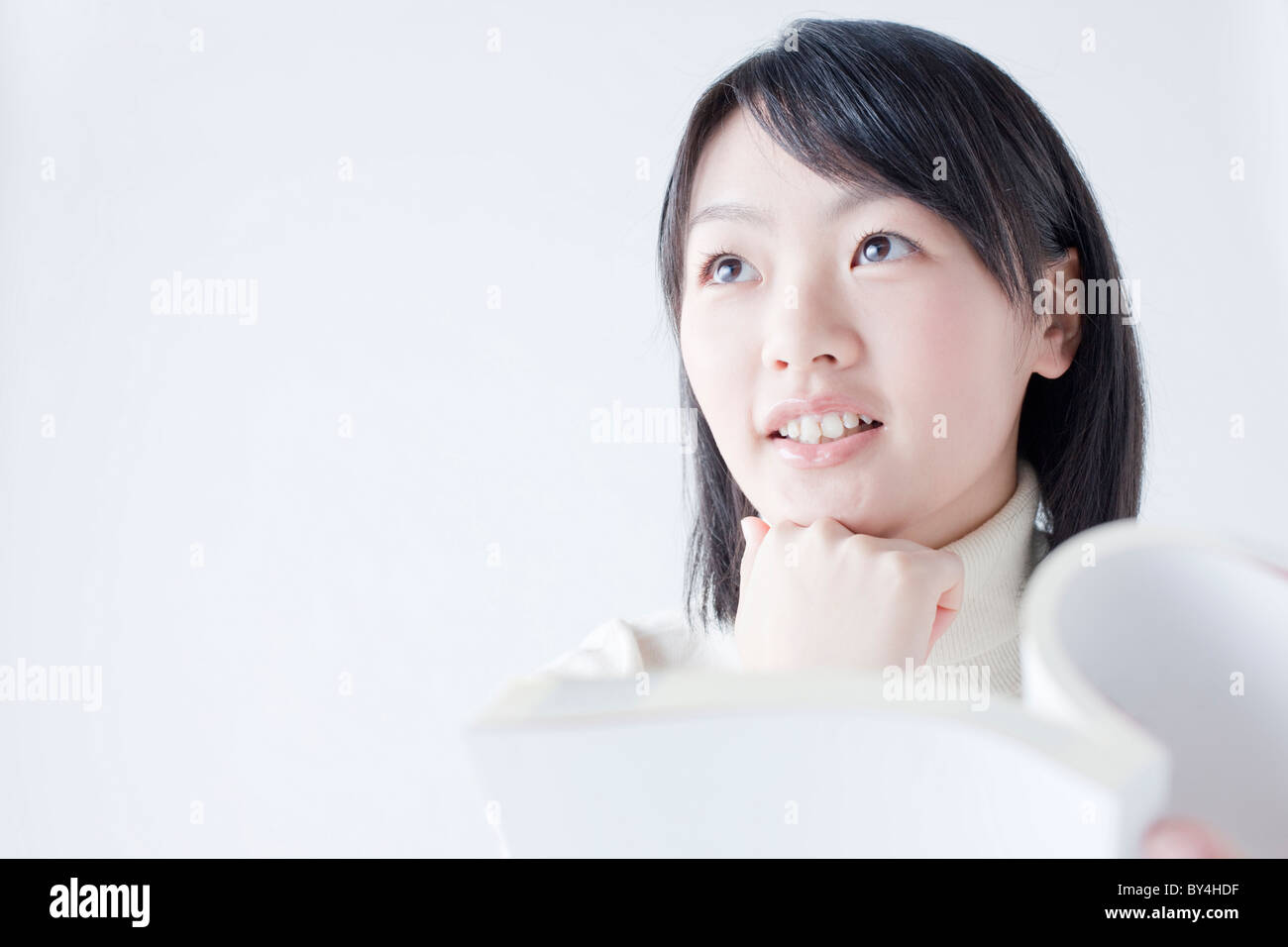 Teenage Girl with Book Thinking Stock Photo - Alamy