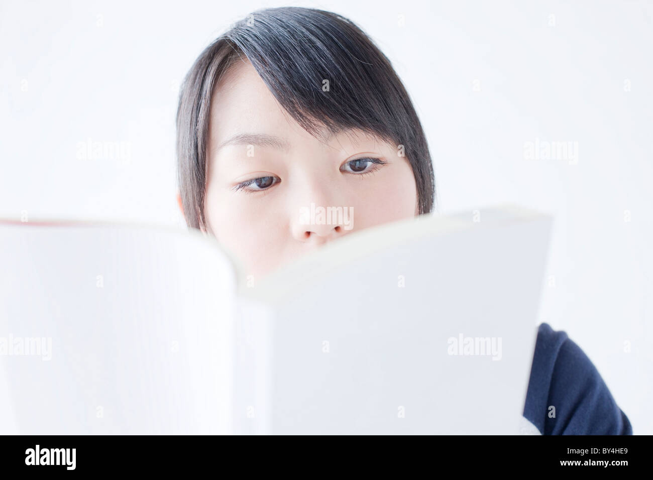 Low Angle view of Teenage Girl Reading Book Stock Photo - Alamy