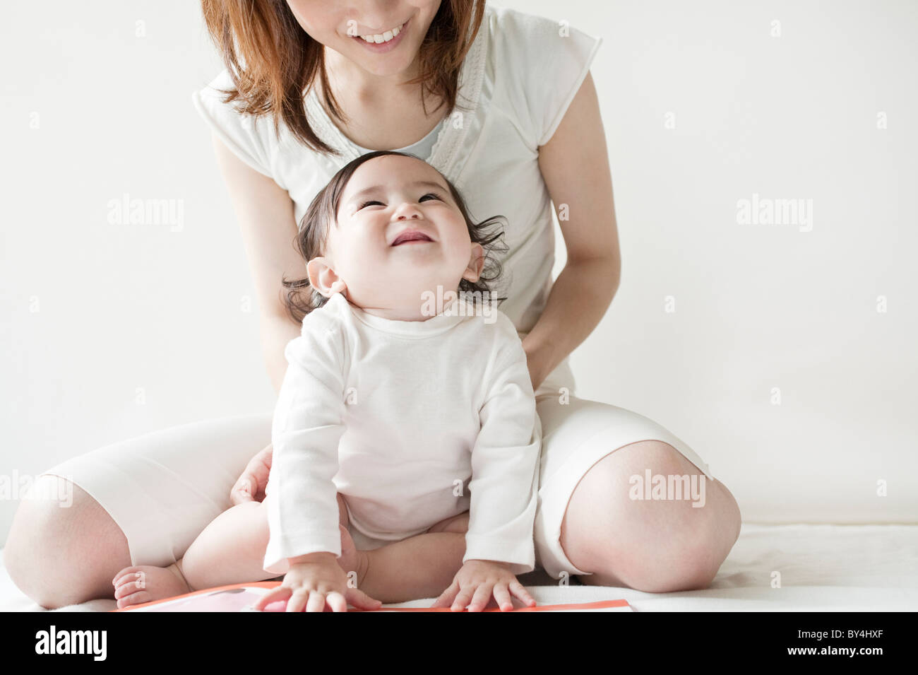 Mother and baby sitting on floor Stock Photo - Alamy