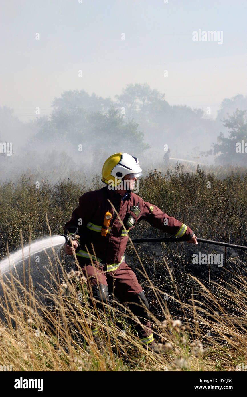 Fireman dragging a hose Stock Photo - Alamy