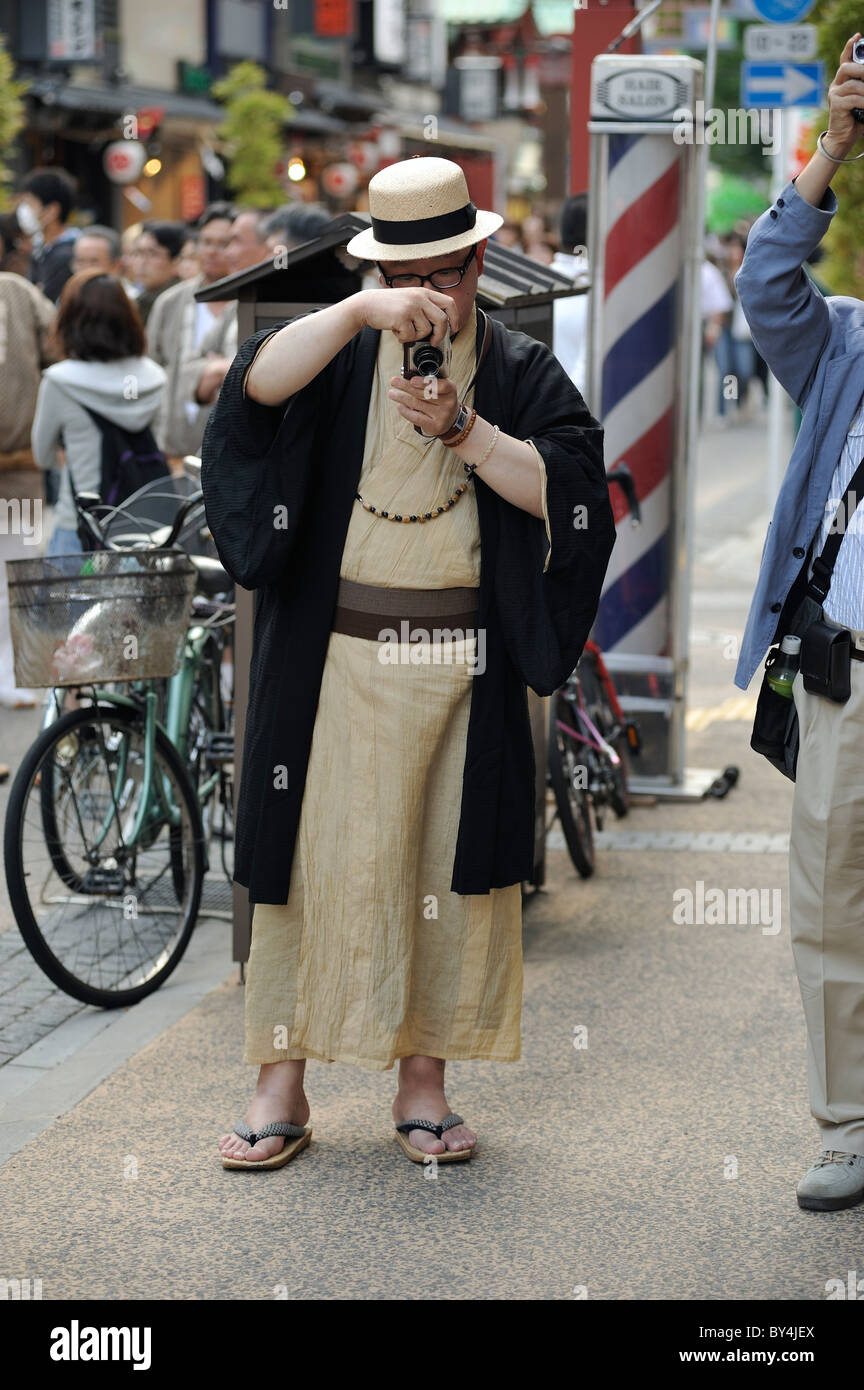 Traditionally dressed Japanese man checking picture on his camera ...