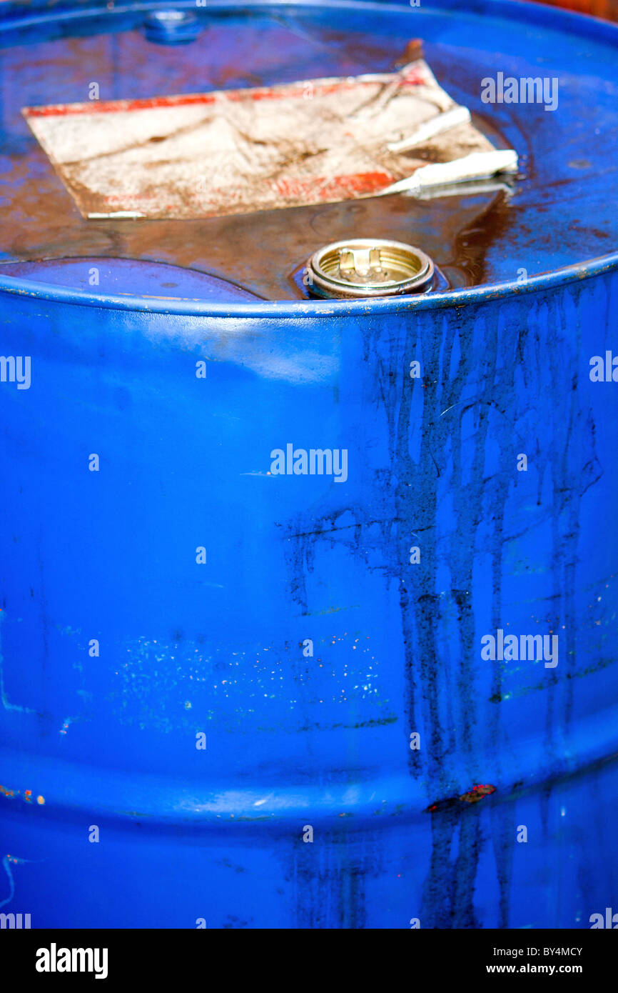 A dumped blue rusted corroded metal drum filled with unknown hazardous ...