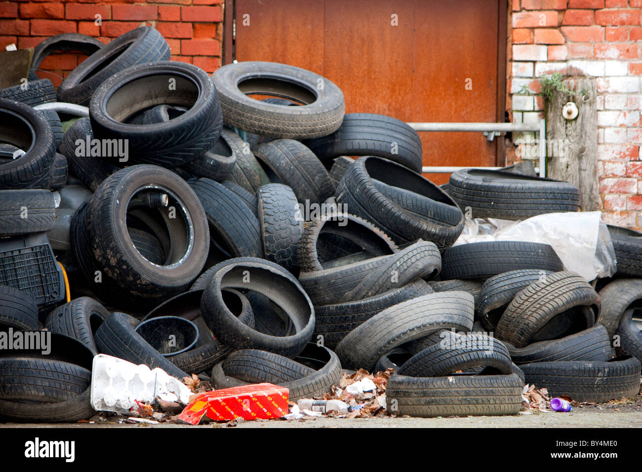 Dumped used rubber tyres showing the tread, some are flat and punctured ...