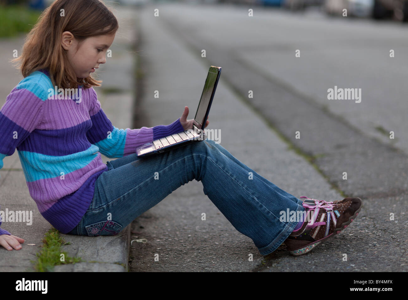 Eight year old girl with laptop outside Stock Photo - Alamy