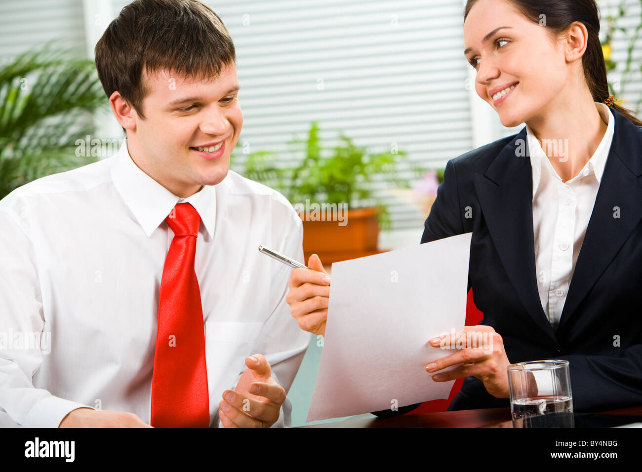Image of pretty business woman giving the pen and paper to man Stock ...