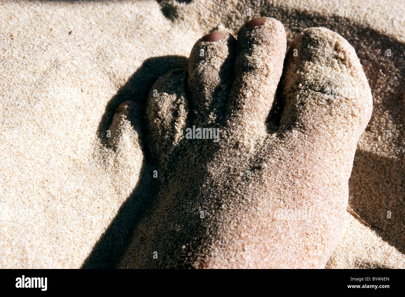 close-up of his feet stuck in the sand on the beach Stock Photo - Alamy