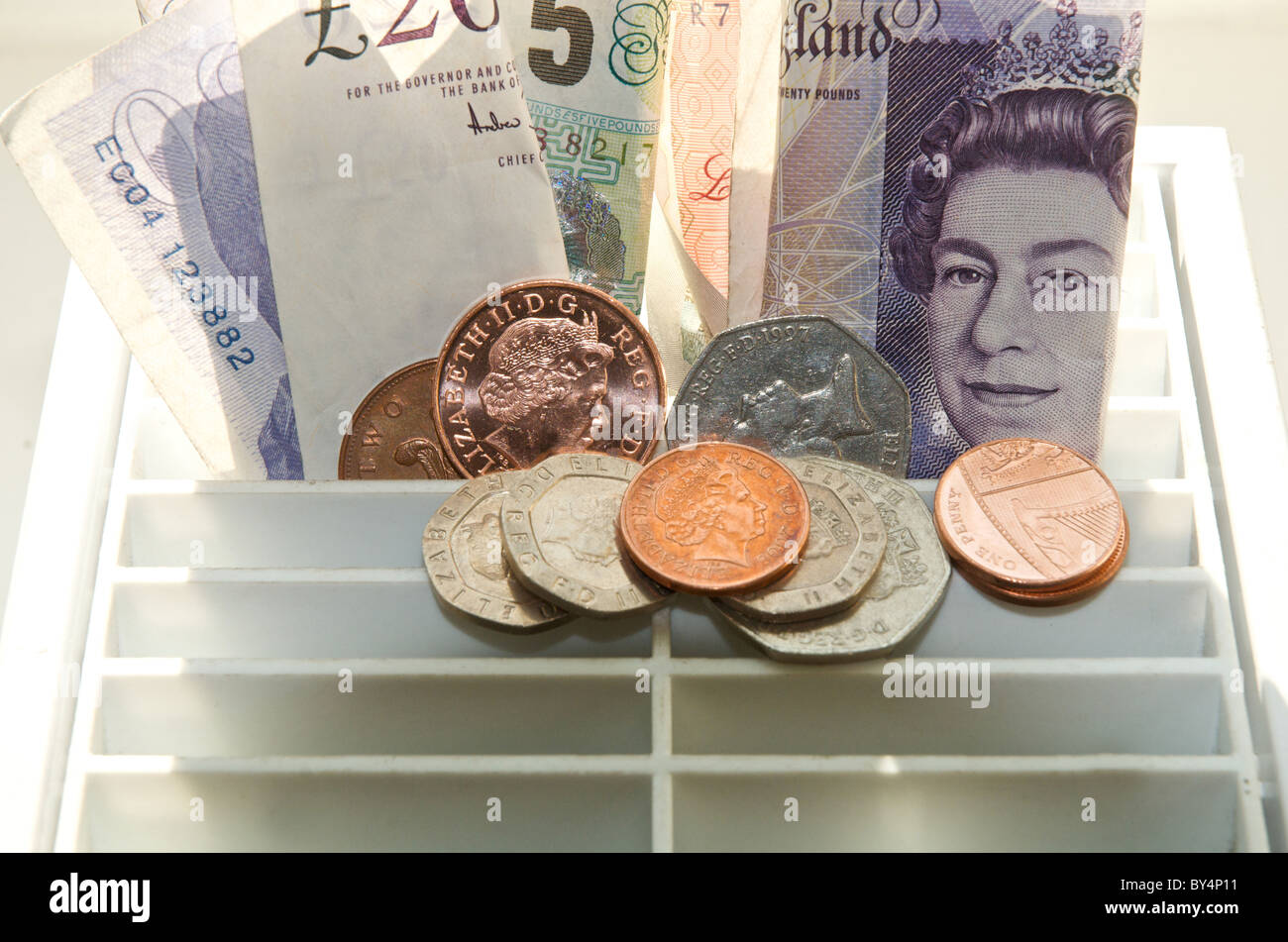 Money down the drain, wasted cash UK currency Stock Photo - Alamy