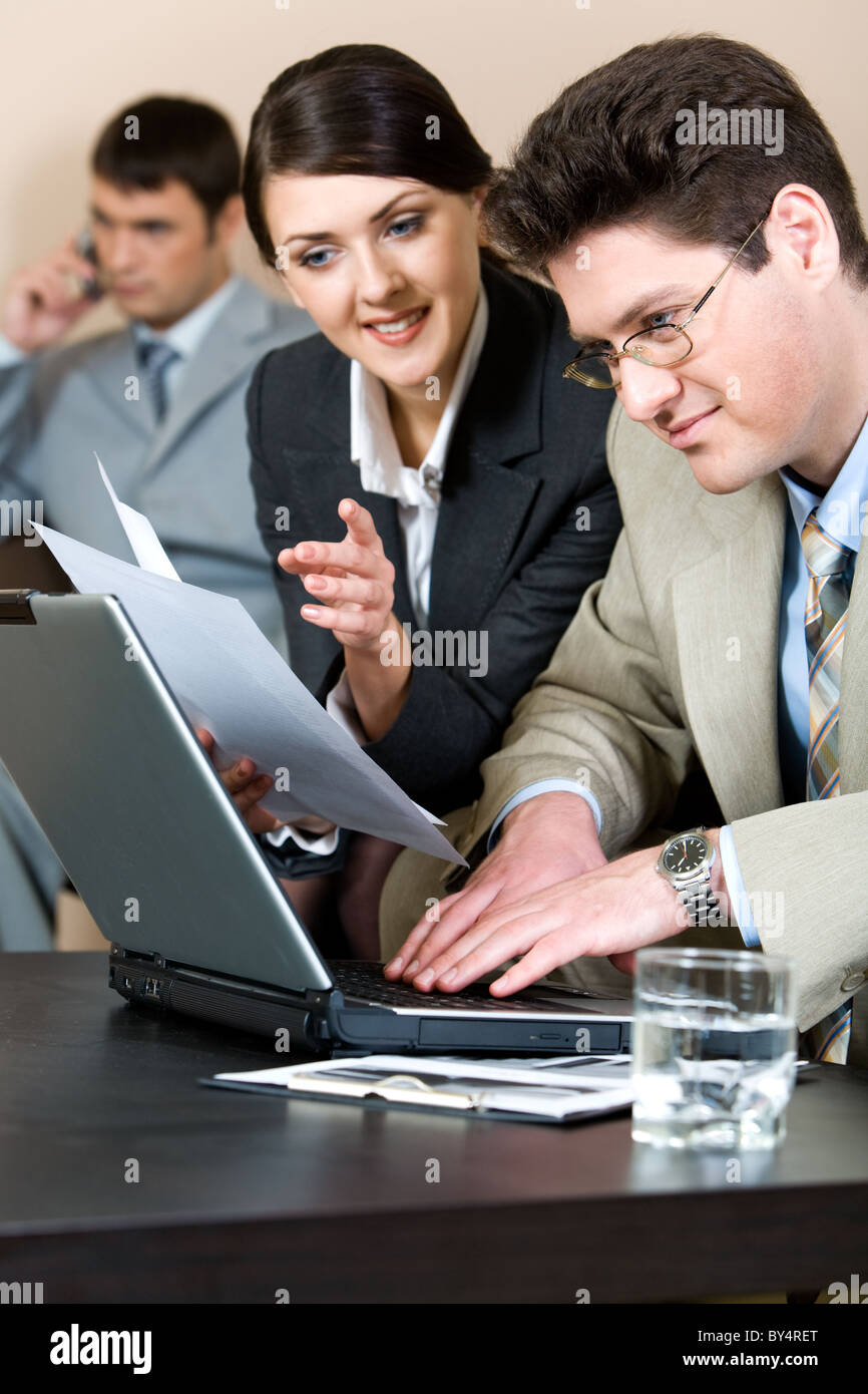 Vertical photo of sitting businessman typing and looking at laptop ...