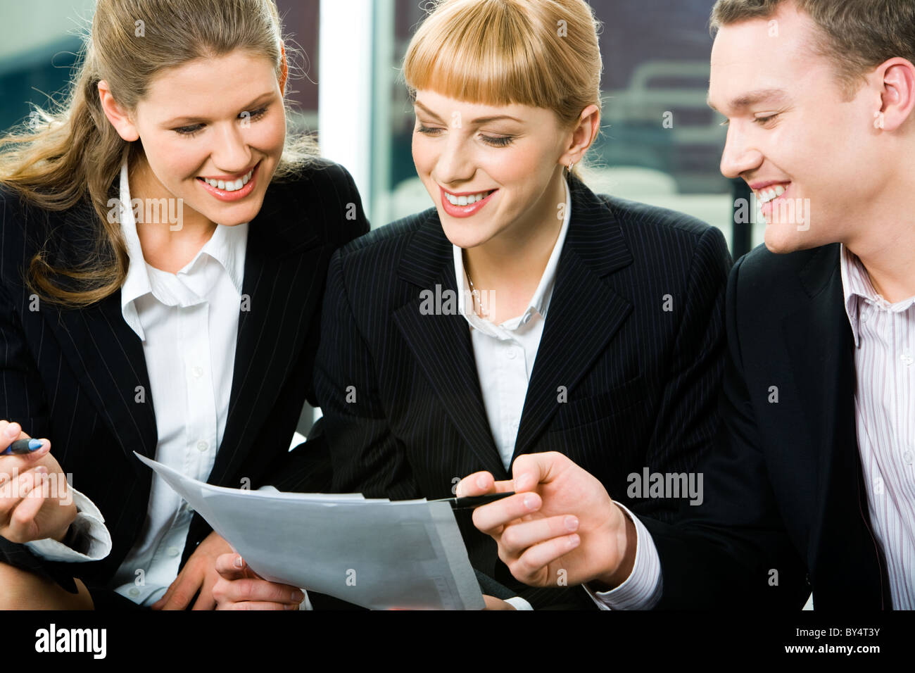 Portrait of three white collar workers looking at the document Stock ...