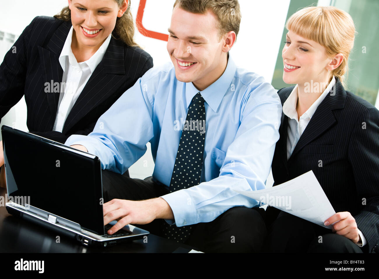 Group of three business people looking at the laptop and sitting Stock ...