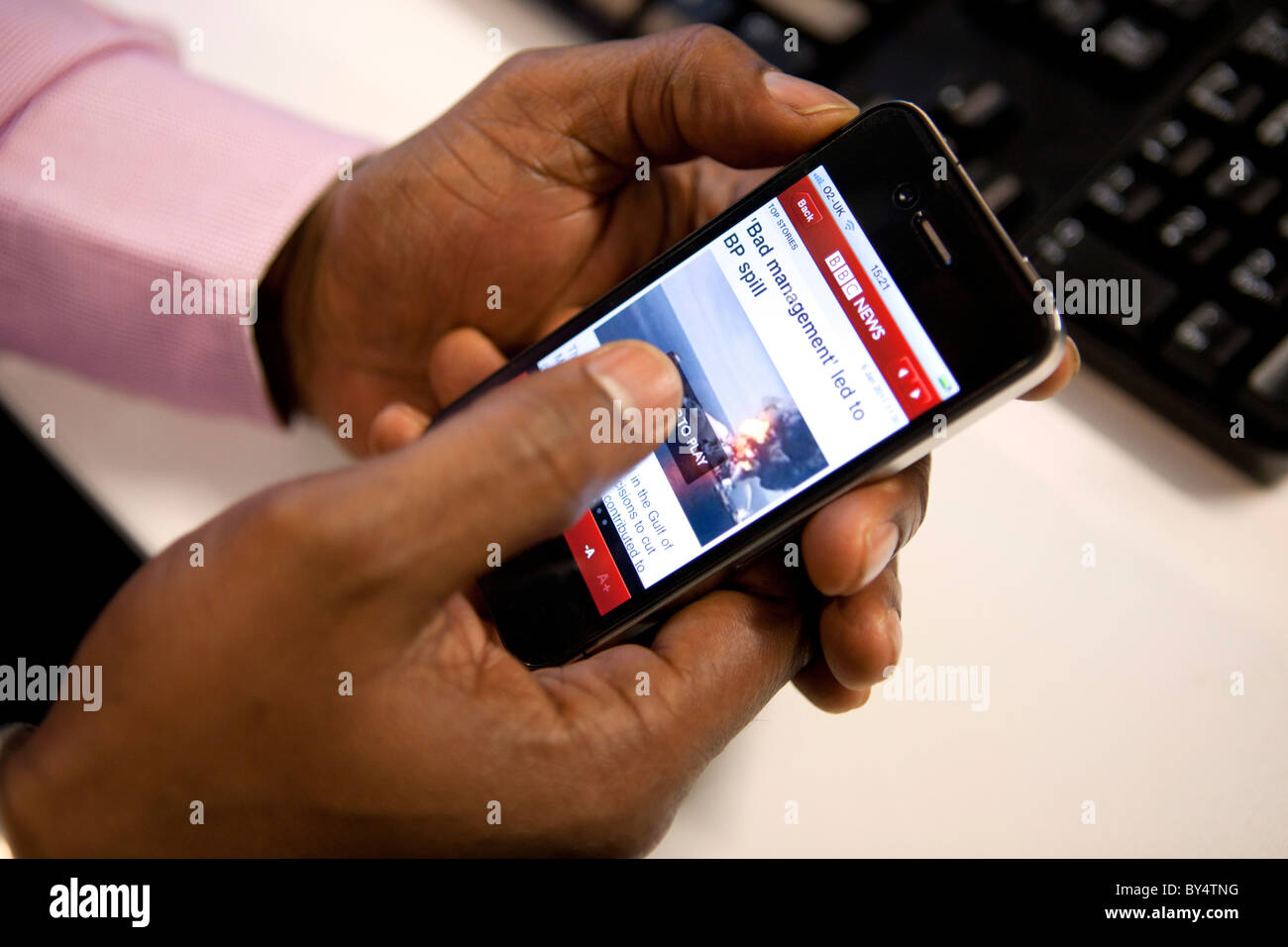 man using iphone in office to access internet Stock Photo - Alamy