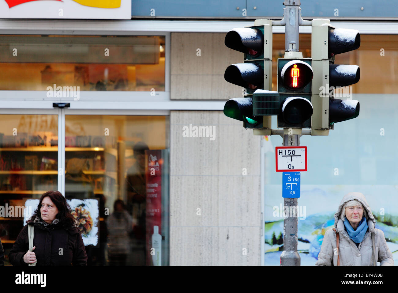 Two elderly women waiting for the change of traffic light on a street ...