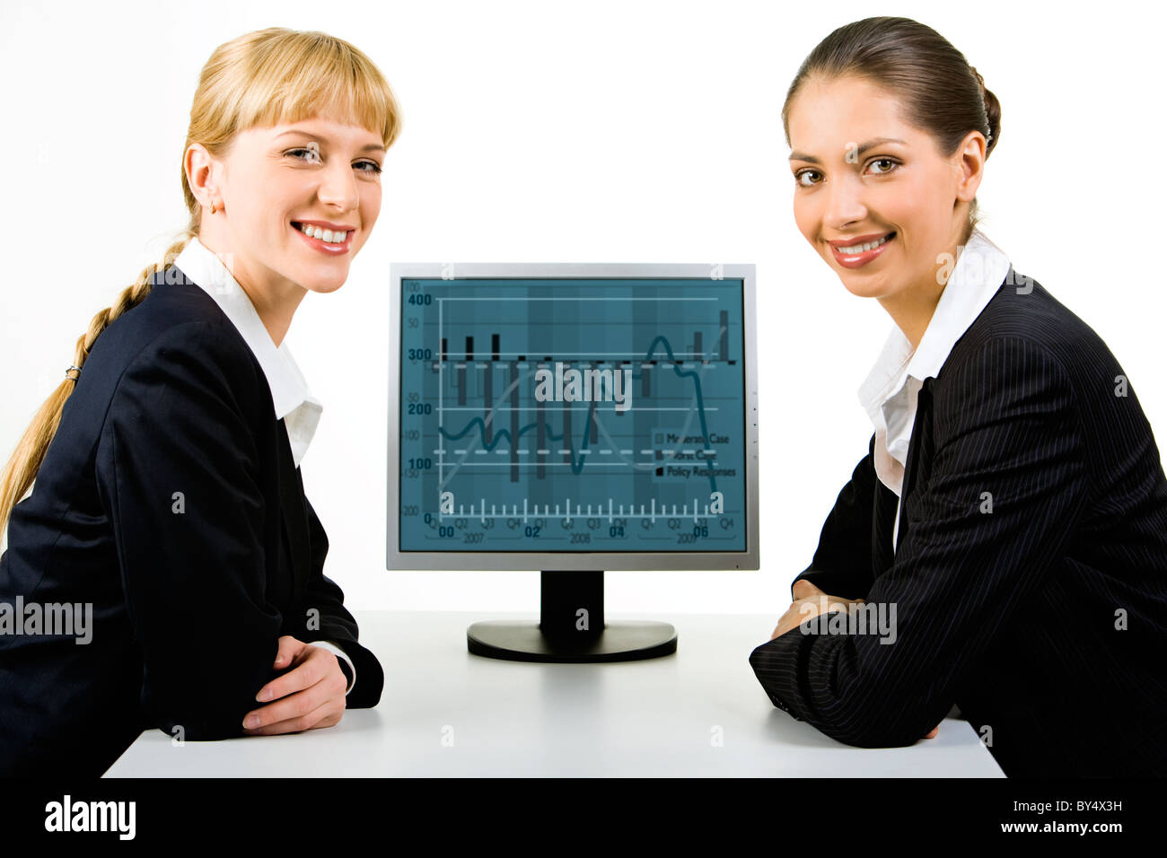 Portrait of two women looking at camera on the background of computer ...