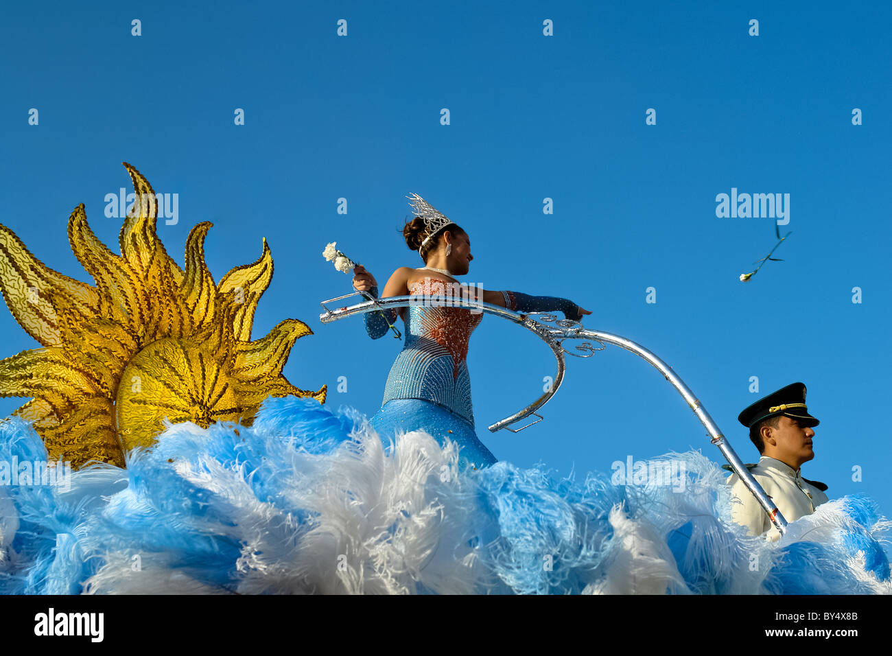 A Colombian girl throws roses from the top of the allegorical float ...