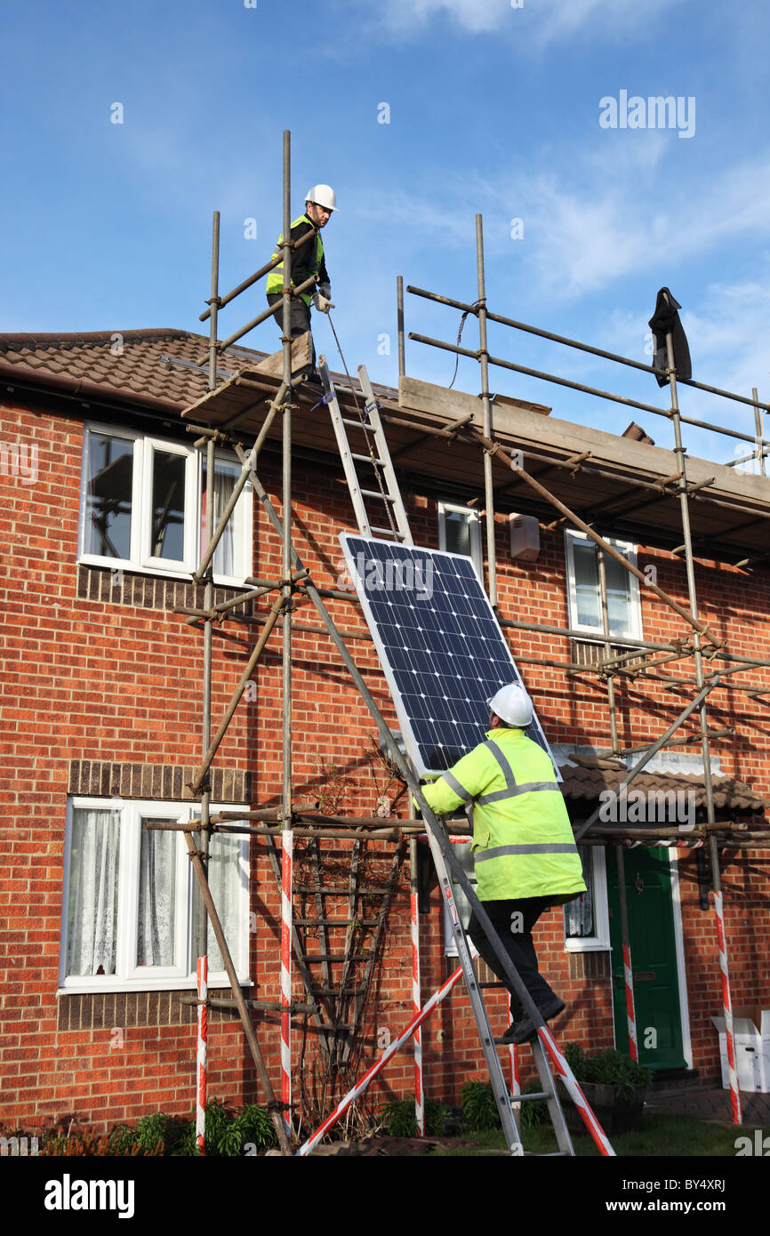 Installing photo voltaic solar panels onto the roof of a domestic house ...