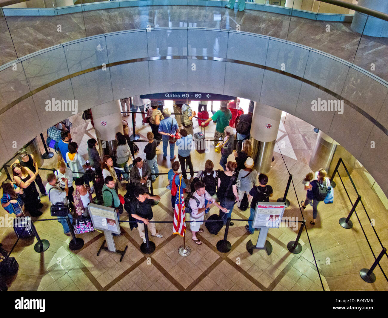 Travelers with their luggage line up for a security check at Los ...