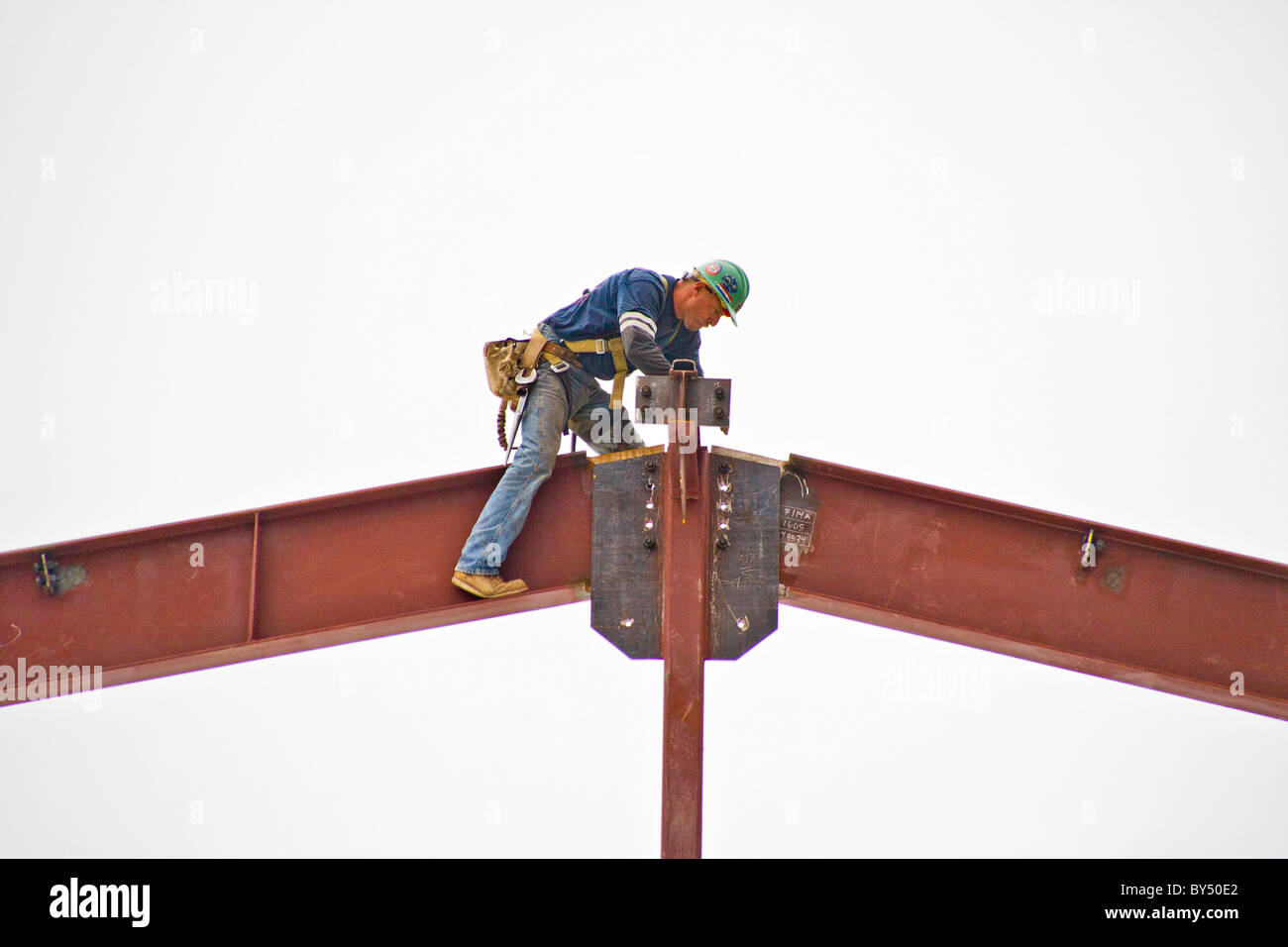 An ironworker assembles the steel frame of a public building in ...