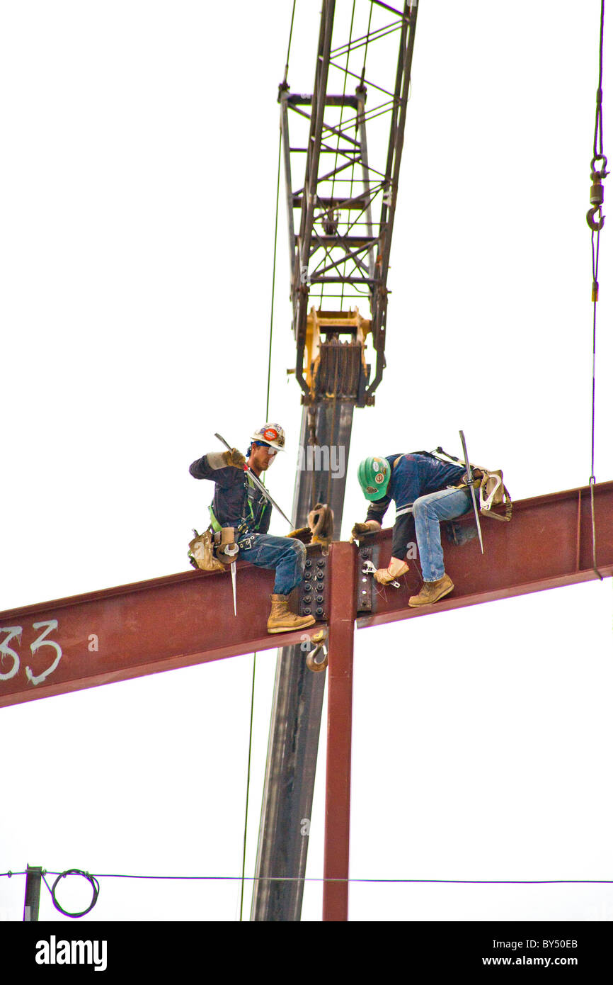 Ironworkers assemble the steel frame of a public building in Southern ...