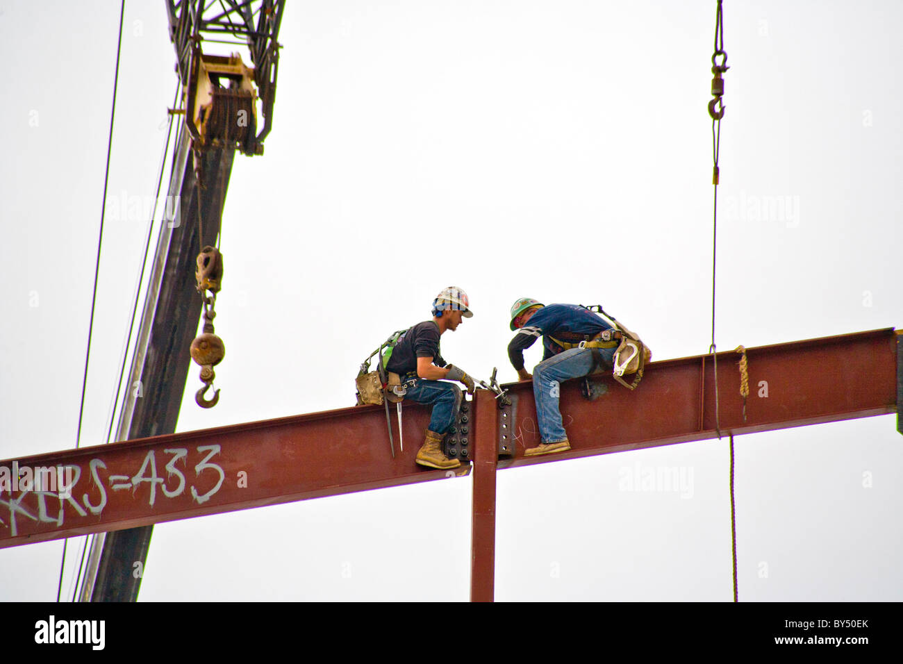 Ironworkers assemble the steel frame of a public building in Southern ...