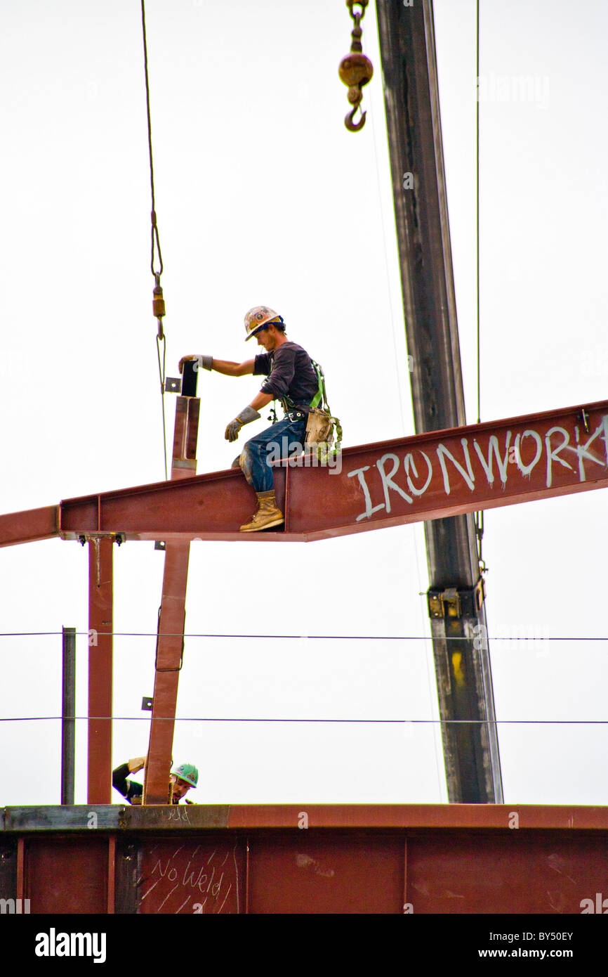 Ironworkers assemble the steel frame of a public building in Southern ...