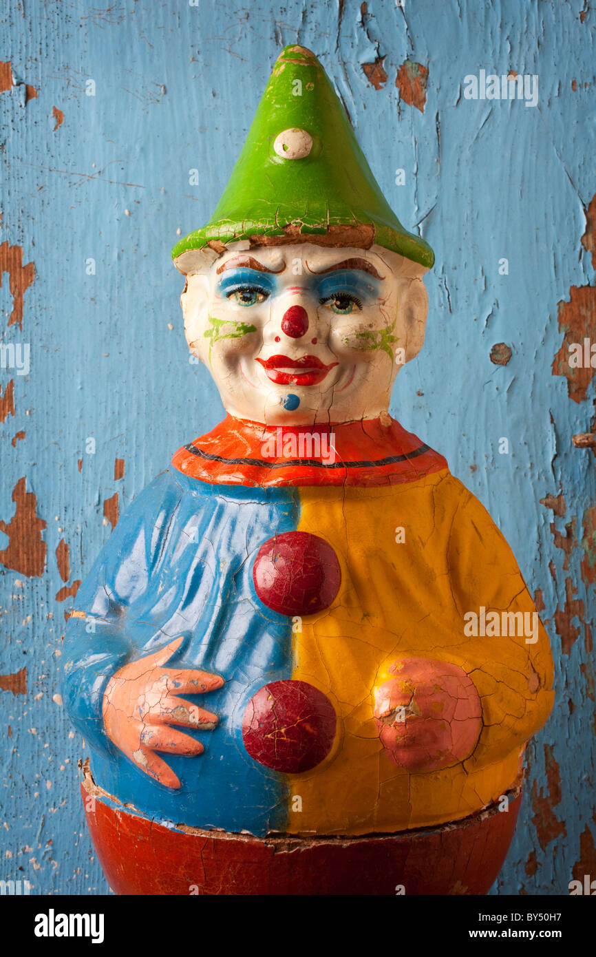 Old clown toy close up against worn blue wall Stock Photo - Alamy