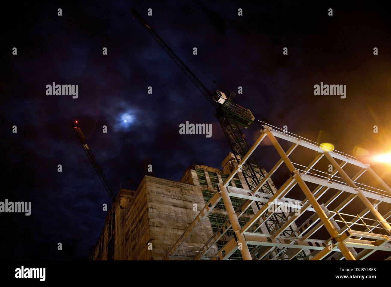 Construction site, tall cranes, full moon and street lights Stock Photo ...