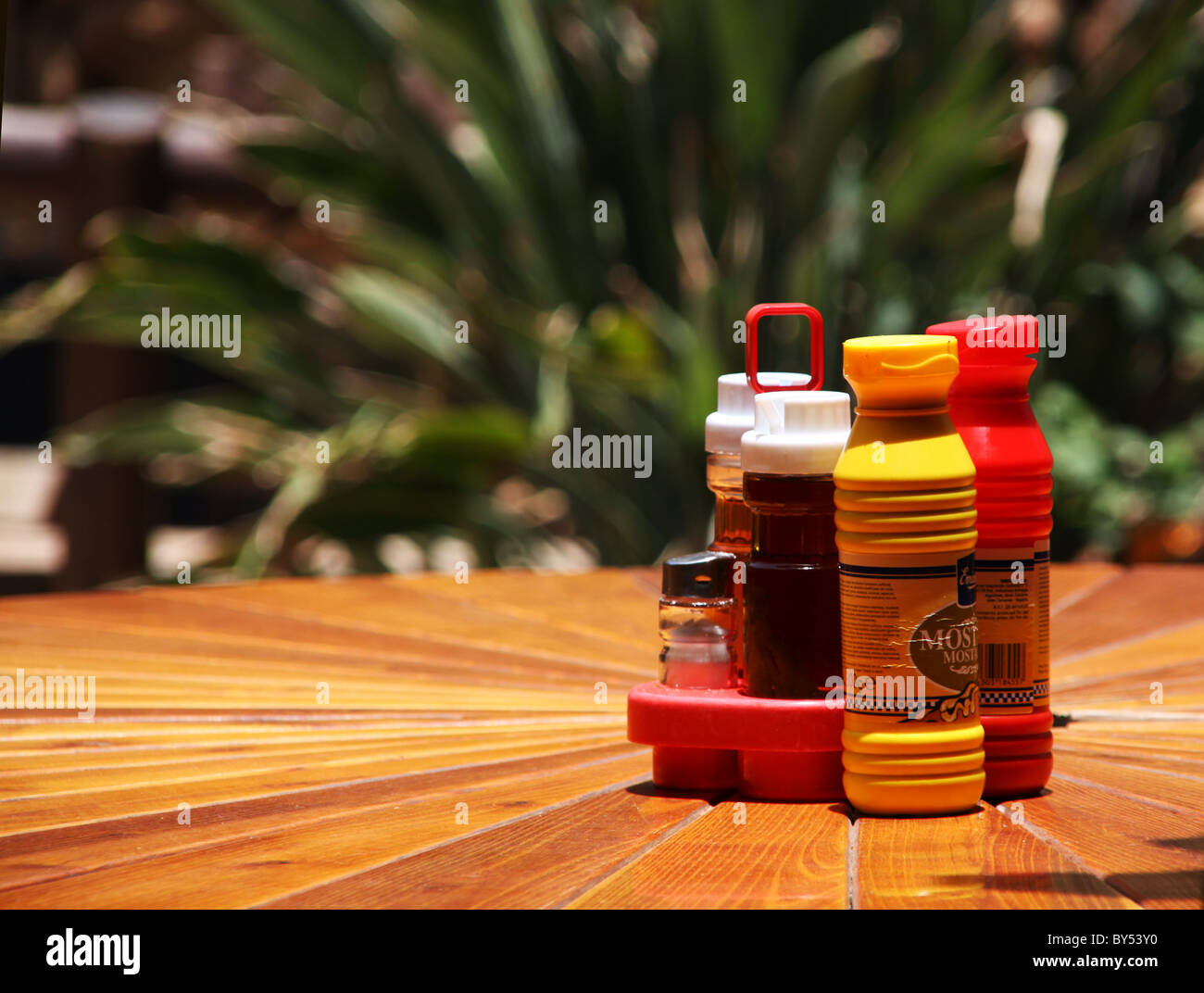 Condiments on wooden café table Stock Photo - Alamy