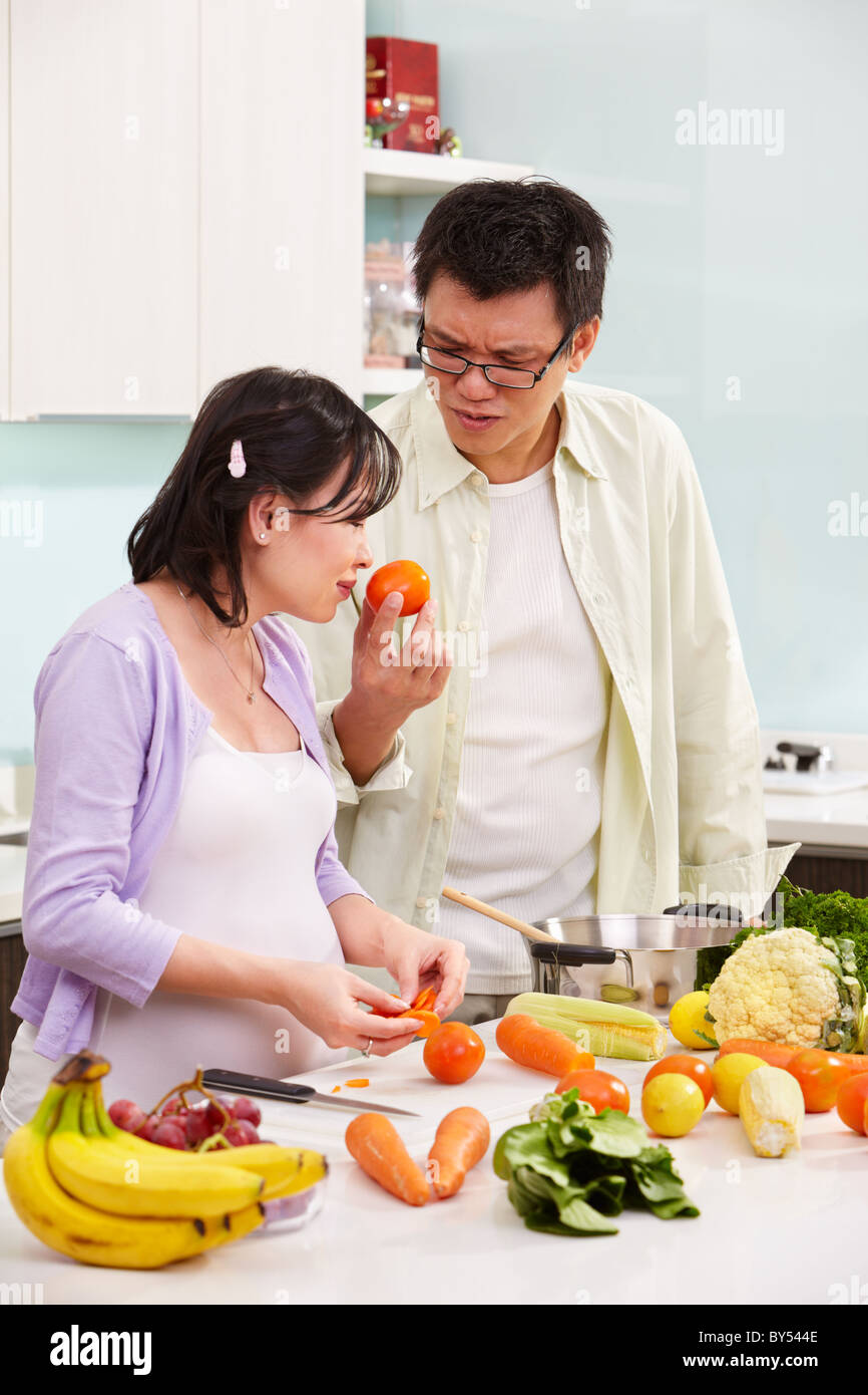 Asian couple ( pregnant wife ) busy preparing food in kitchen Stock ...