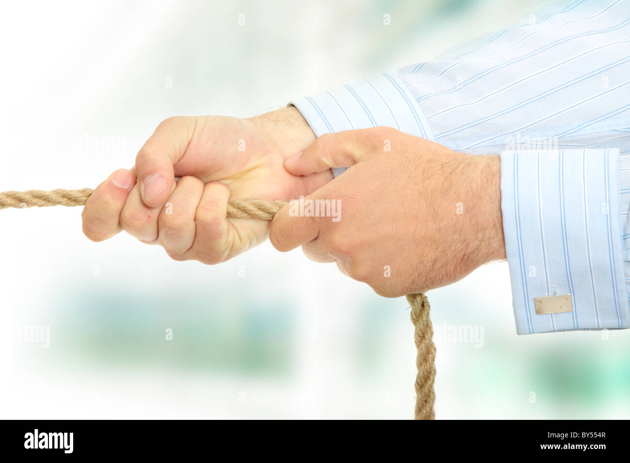 Businessman pulling on a piece of rope Stock Photo - Alamy