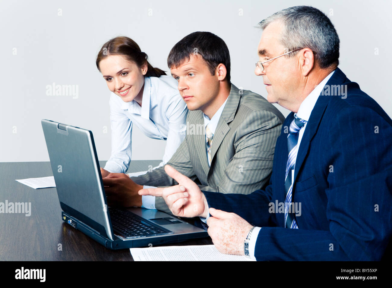 Image of confident boss explaining some computer work to coworkers ...