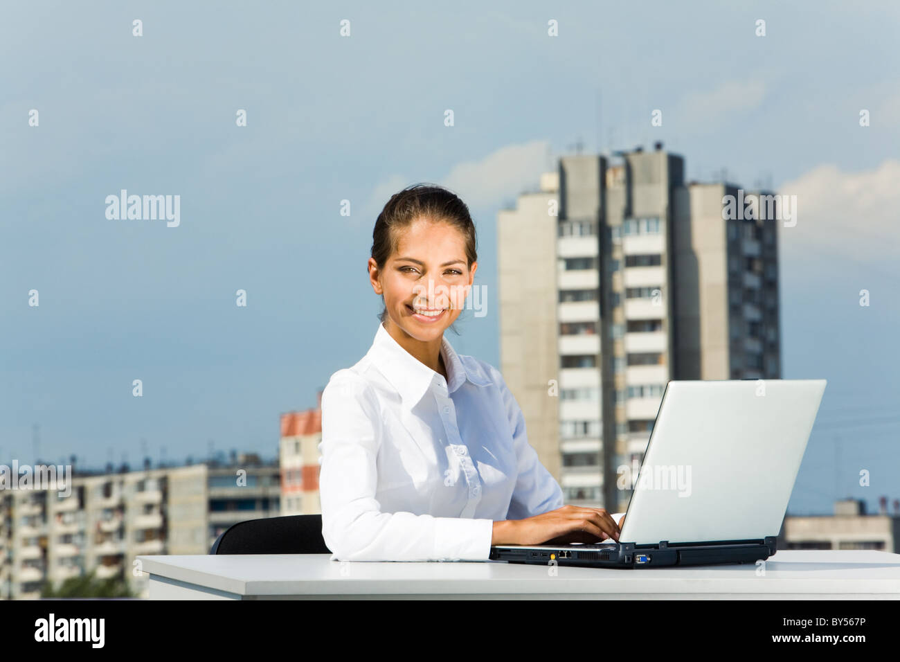 Successful business lady working with laptop somewhere outside and ...