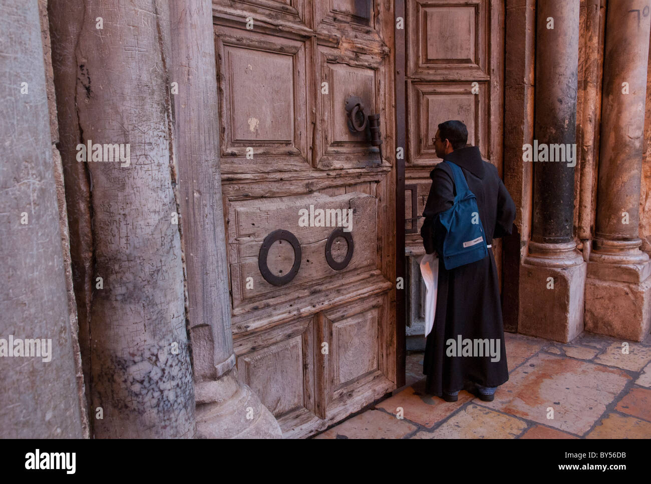 Priest standing at the entrance gate to the Holy sepulcher. jerusalem ...
