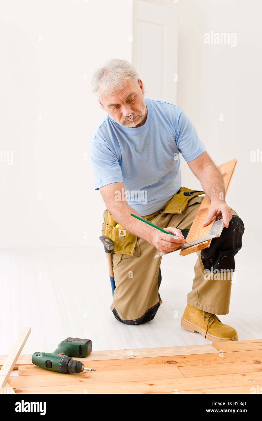 Home improvement - handyman installing wooden floor home Stock Photo ...