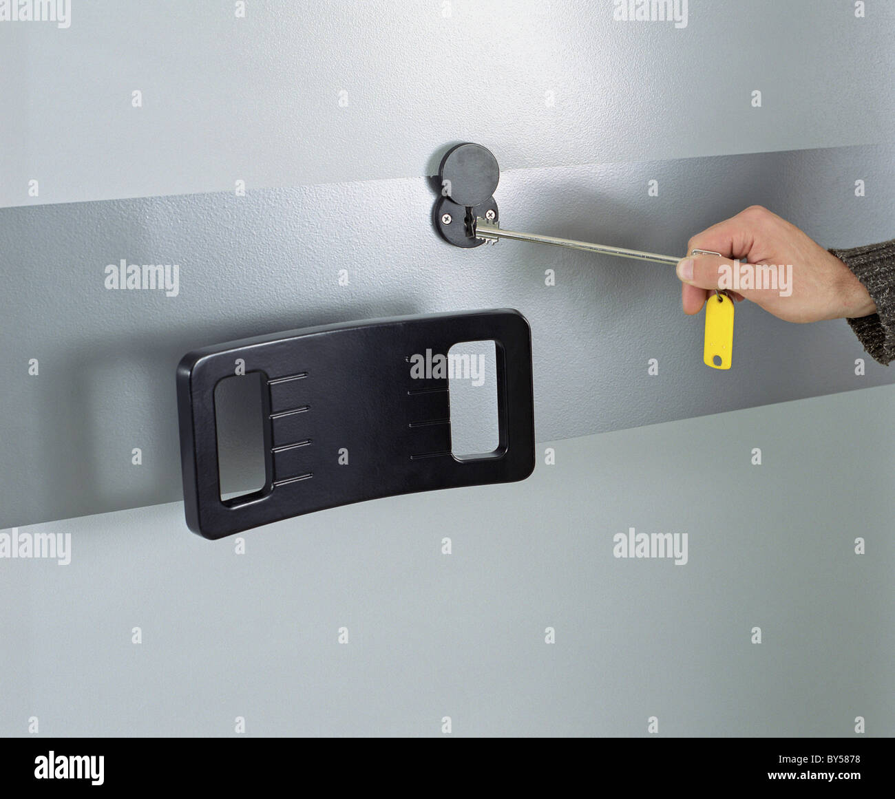 Detail of a man opening a safe with a key Stock Photo - Alamy