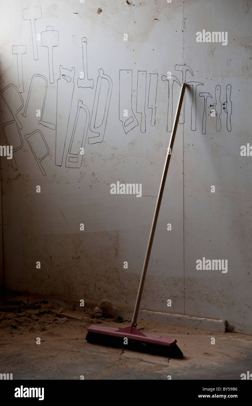 A broom leaning against a wall in a workshop Stock Photo - Alamy