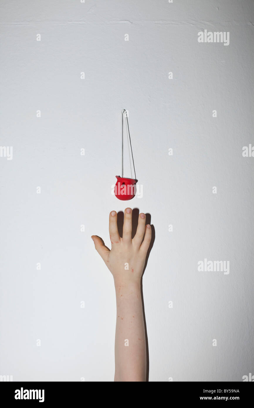 A hand reaching up a wall for a clown's nose Stock Photo - Alamy