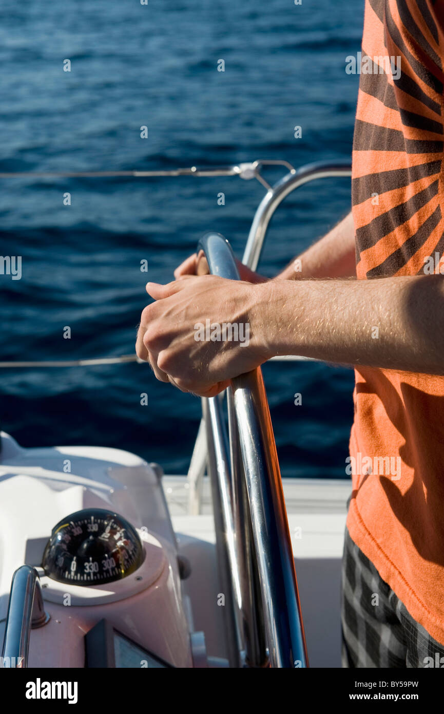 Man at the helm of a yacht Stock Photo - Alamy