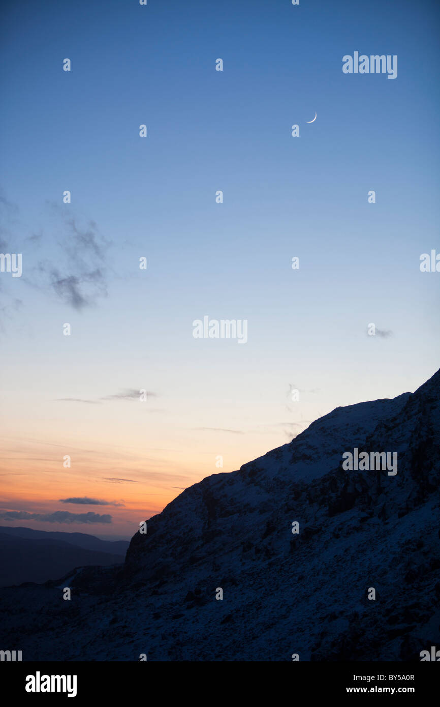 Sunset over Red Screes with a new moon, in the Lake District, UK Stock ...