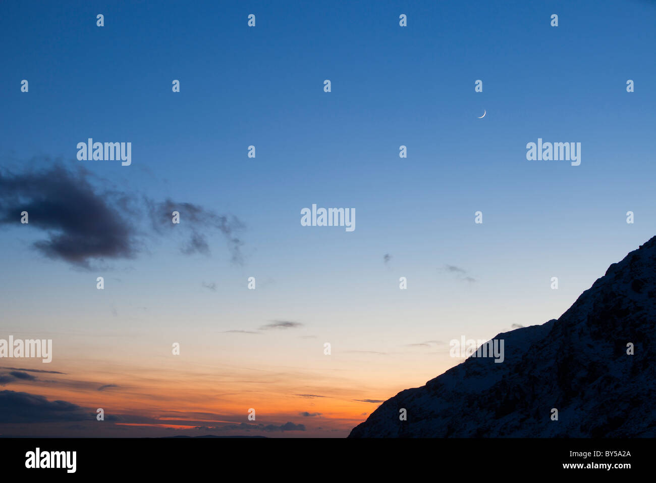Sunset over Red Screes with a new moon, in the Lake District, UK Stock ...