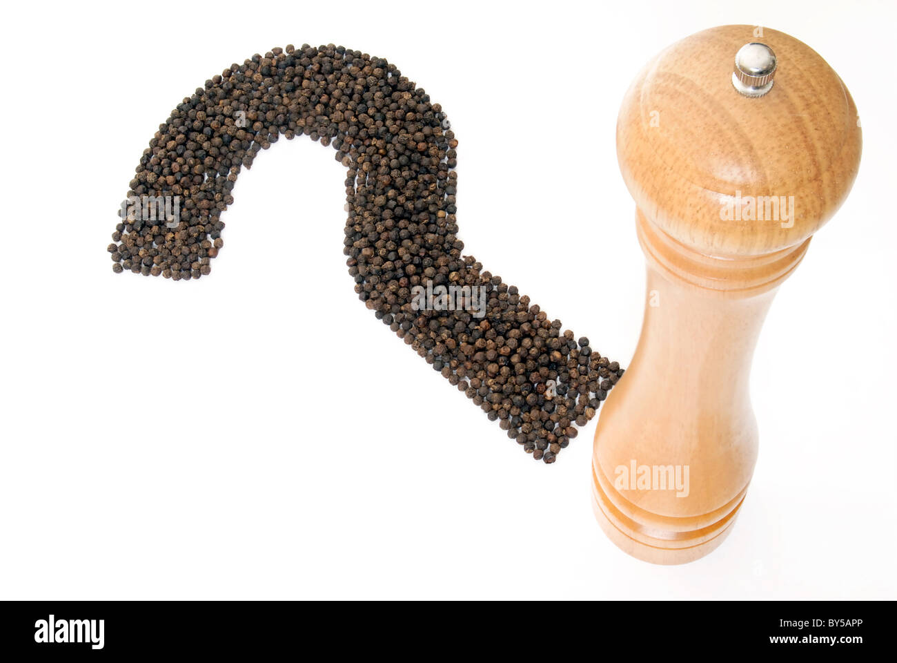 Pepper mill with a pepper corn shaped question mark on a white ...