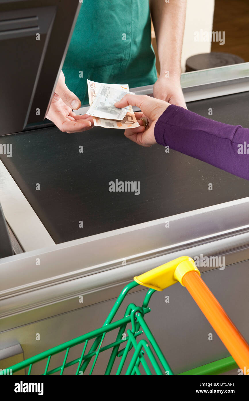 A customer handing a cashier cash at the supermarket Stock Photo - Alamy