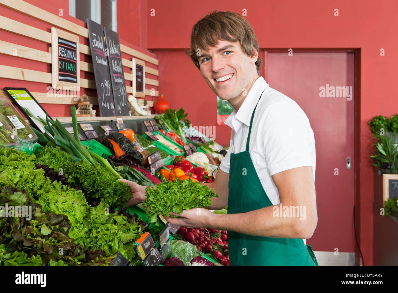 A grocery stocker stocking leaf lettuce Stock Photo - Alamy