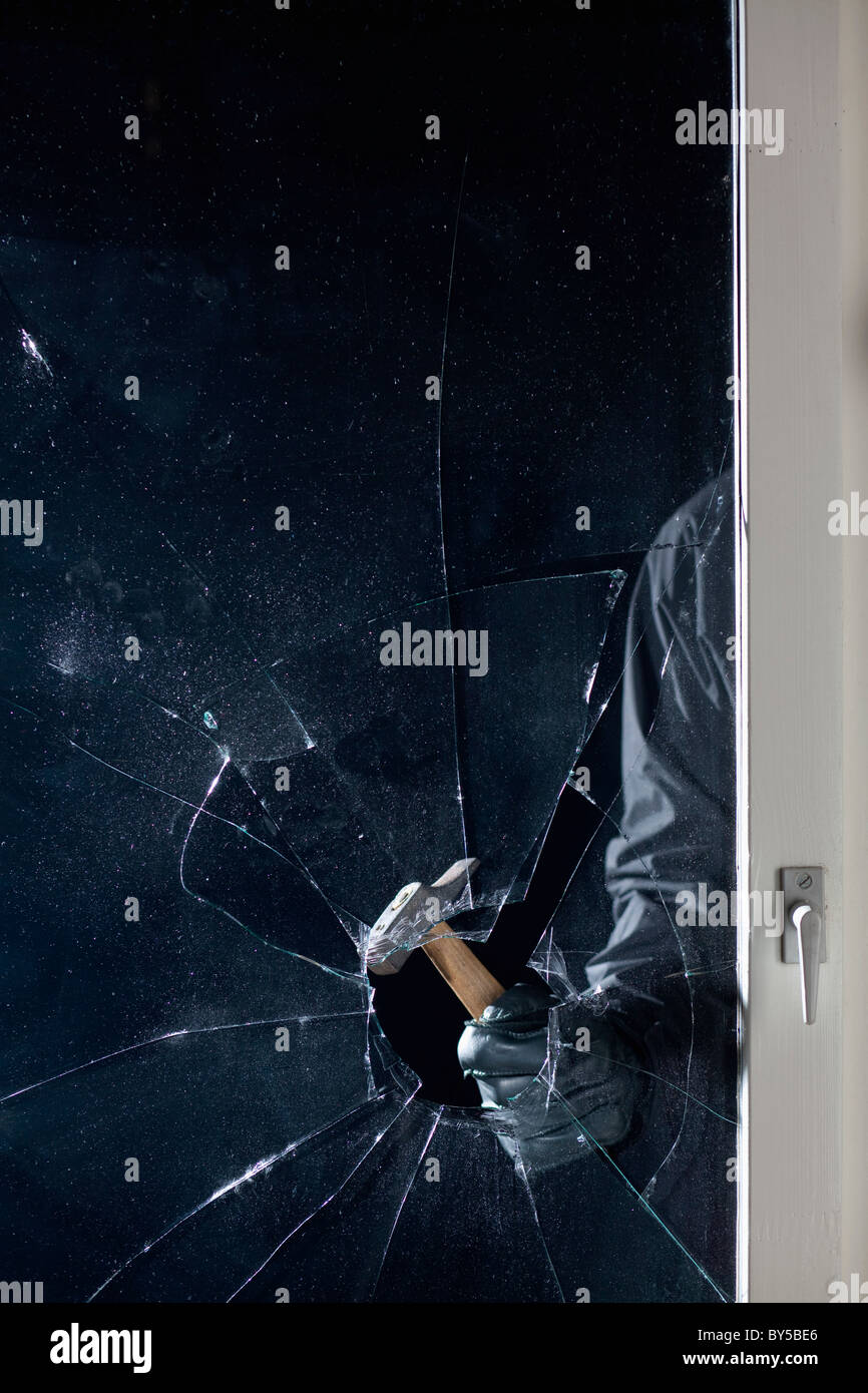 A criminal breaking into a window, focus on hand Stock Photo - Alamy