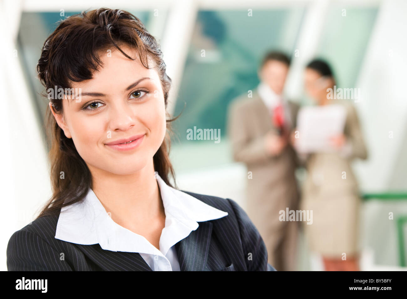 Portrait of pretty business leader in working environment looking at ...