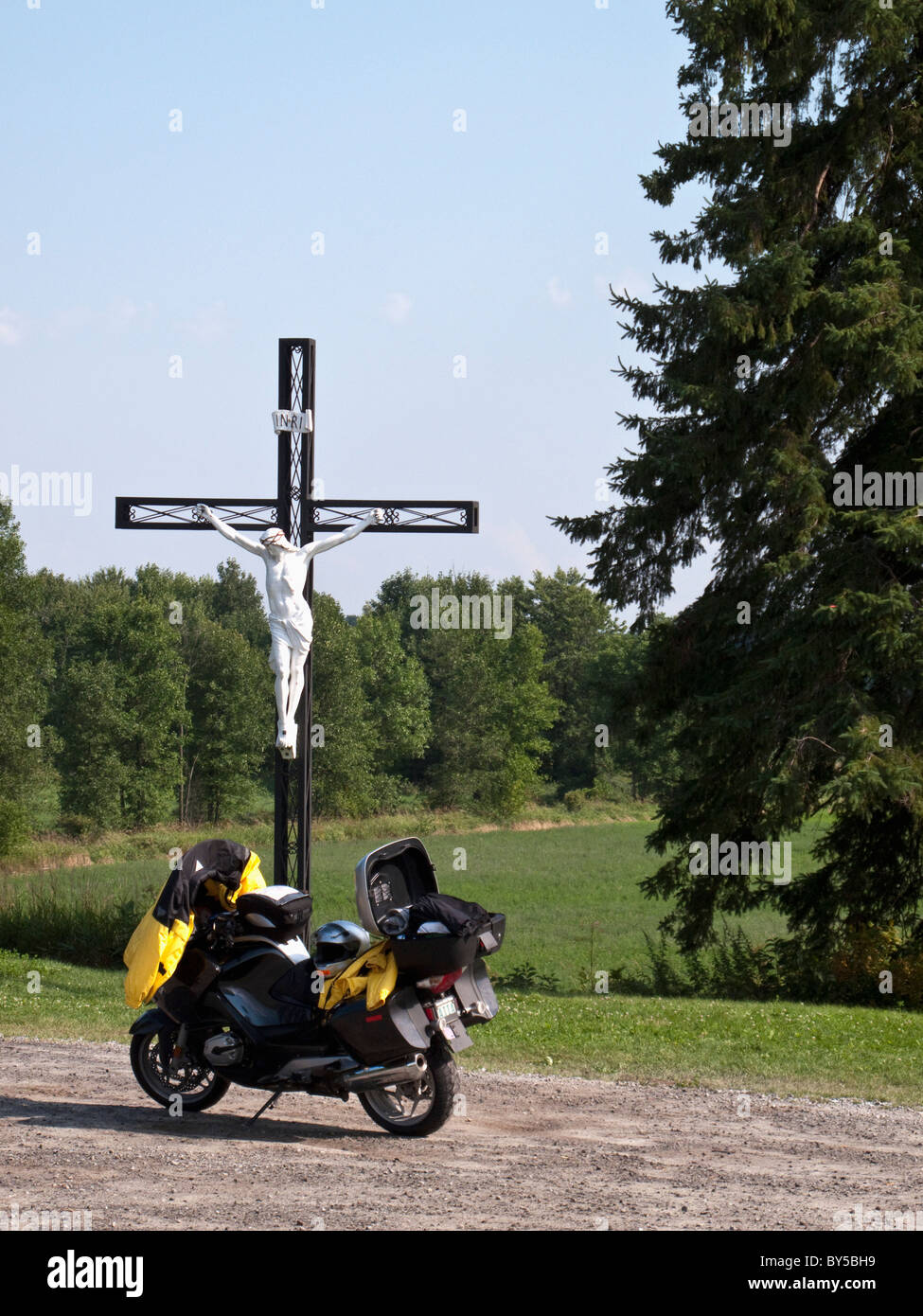 A motorcycle parked next to a crucifix in a rural area Stock Photo - Alamy